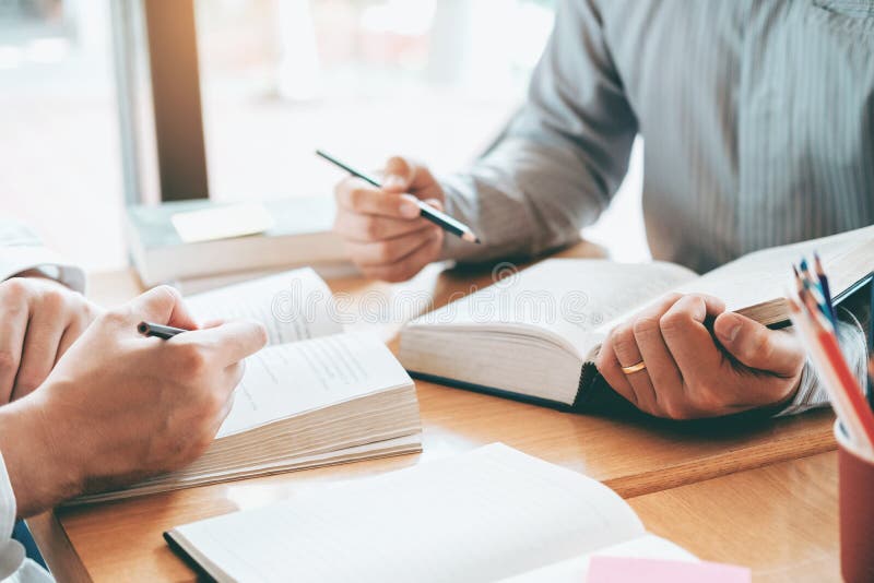 High School or College Students Studying and Reading Together in ...