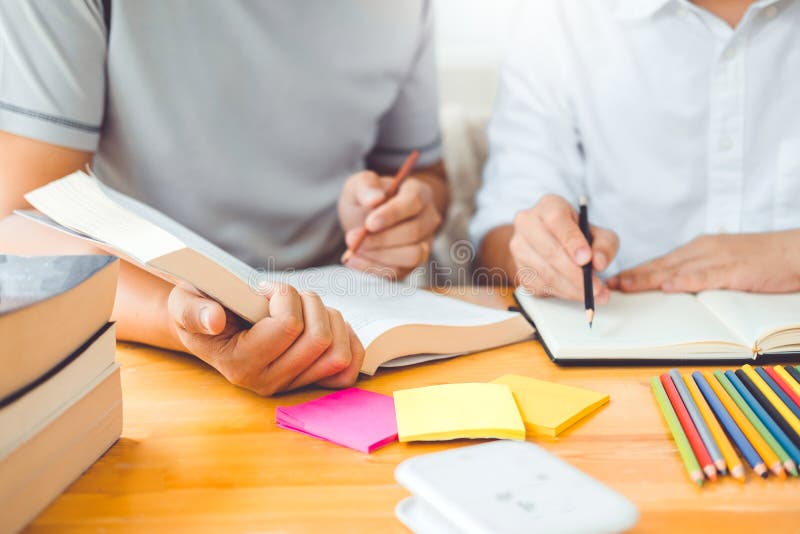 High School or College Students Studying and Reading Together in ...