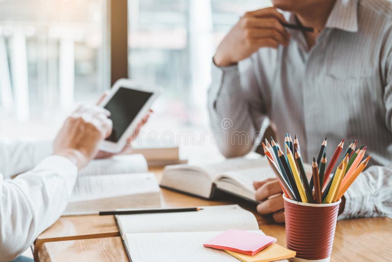 High School or College Students Studying and Reading Together in ...