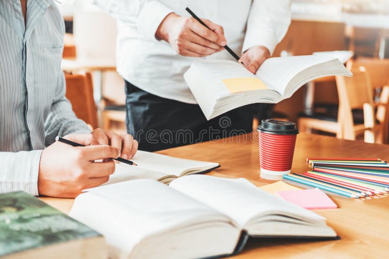 High School or College Students Studying and Reading Together in ...