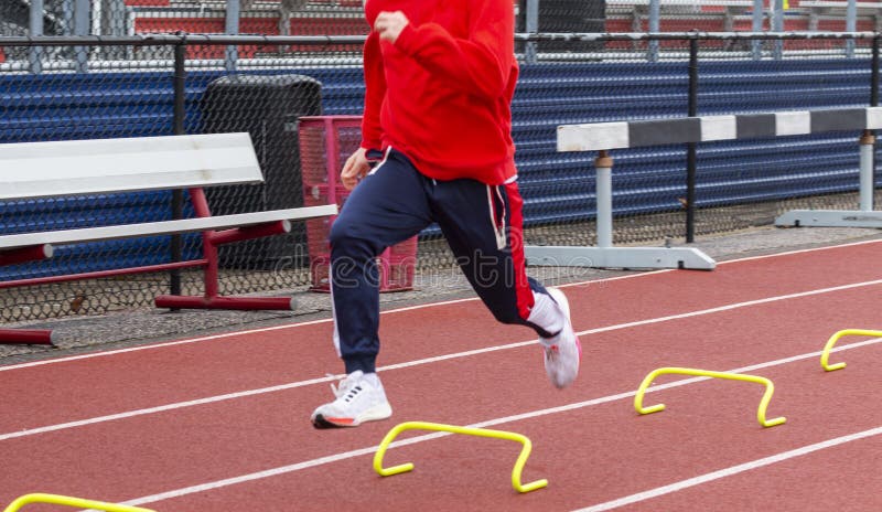 High School Sprinter Running Over Six Inch Mini Hurdles on a Track ...