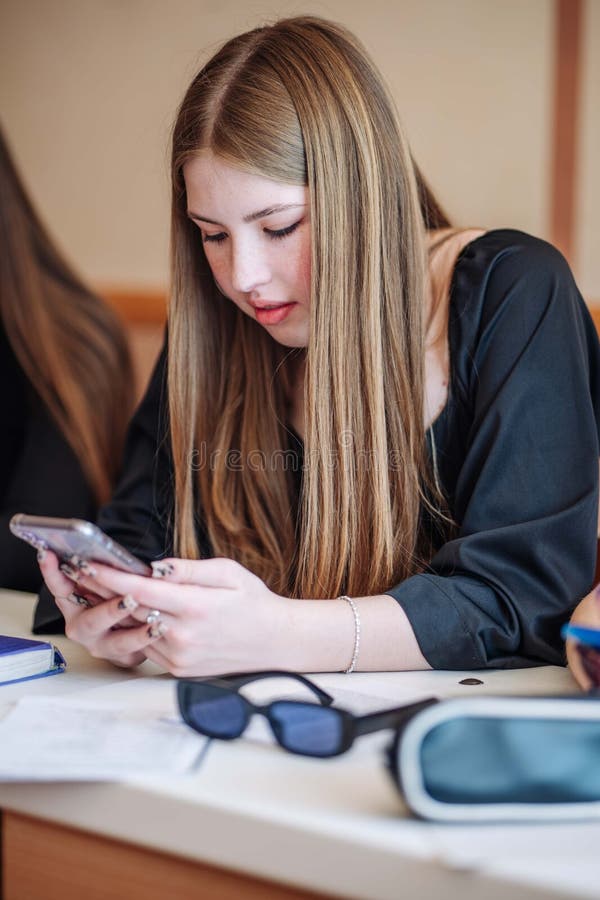 High School Student Using Mobile Phone in Classroom while Studying ...