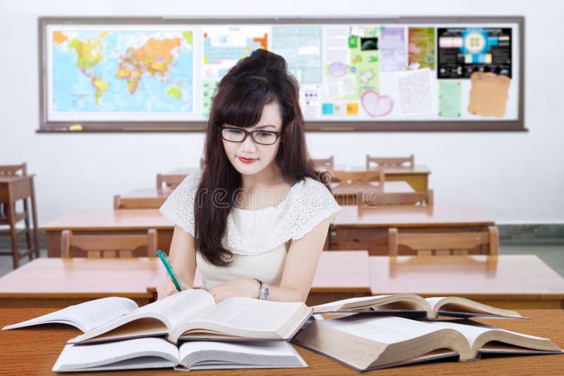 High School Student Writing on Book in Class Stock Image - Image of ...
