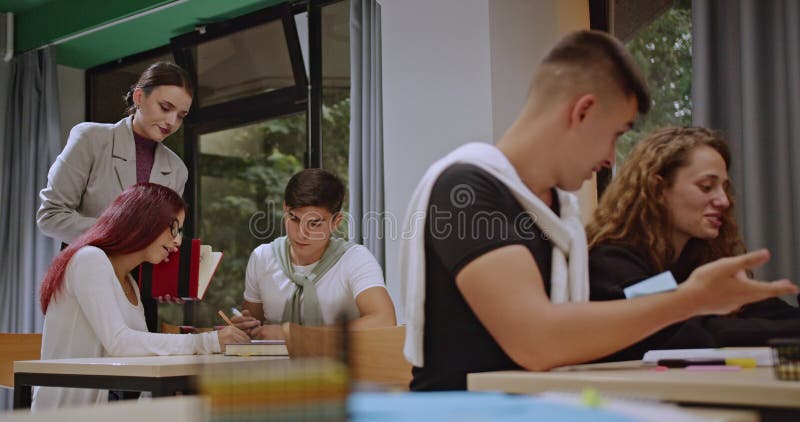 High School Students Collaborate on a Project during Class with the Help of Their Teacher. Stock ...