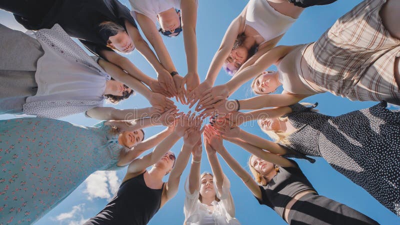 High School Students Forming a Hand in Hand Circle Against a Clear Blue ...