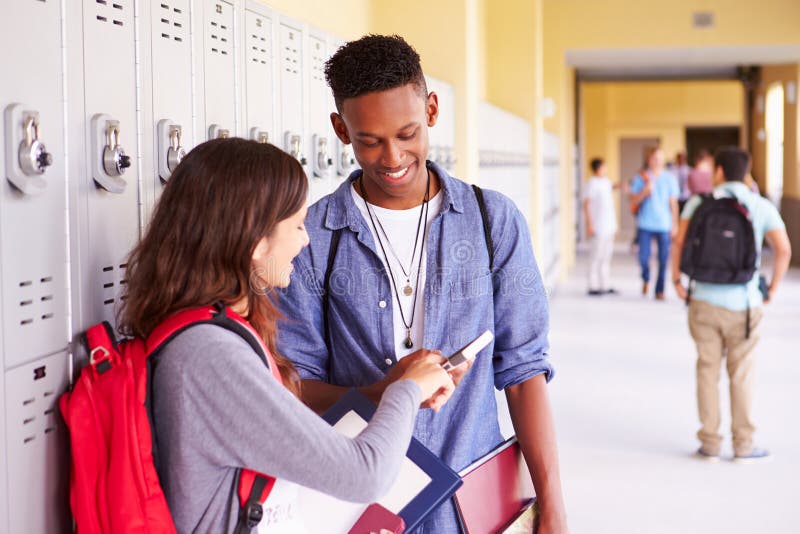 High School Students by Lockers Looking at Mobile Phone Stock Image ...