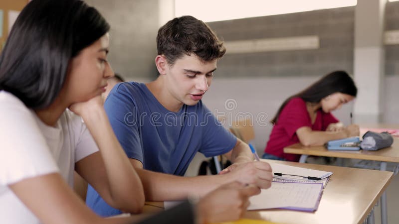 High School Students Sitting at Table Studying Together in Classroom ...