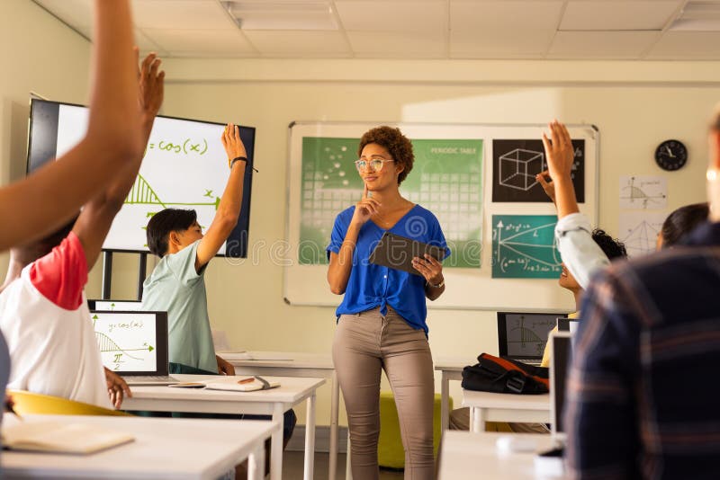 In High School, Teacher Holding Tablet and Engaging Students Raising ...