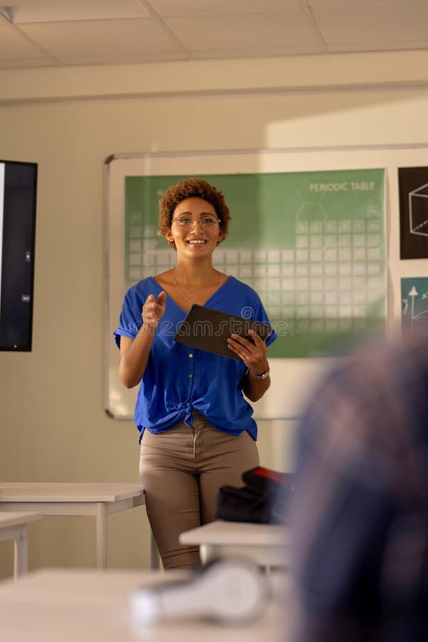 In High School, Teacher Holding Tablet and Giving Presentation in ...