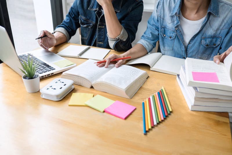 High School Tutor or College Student Group Sitting at Desk in Library ...
