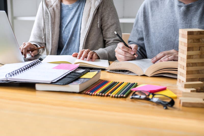 High School Tutor or College Student Group Sitting at Desk in Library ...
