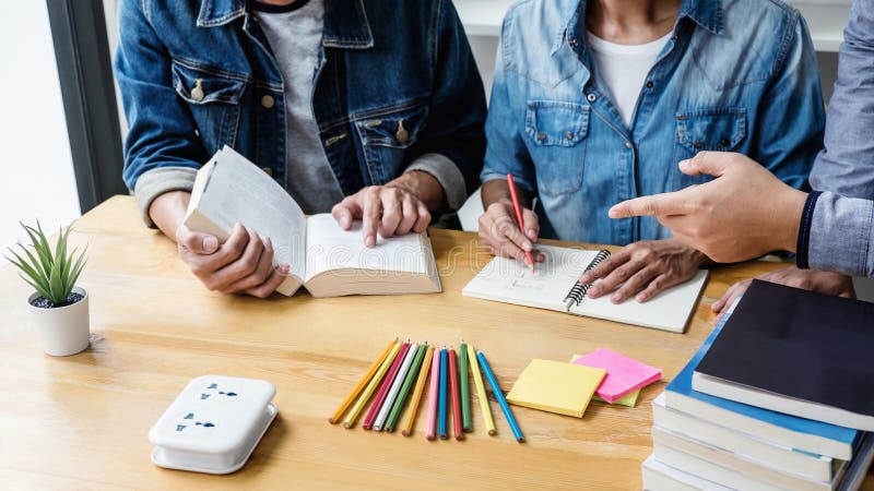 High School Tutor or College Student Group Sitting at Desk in Library ...