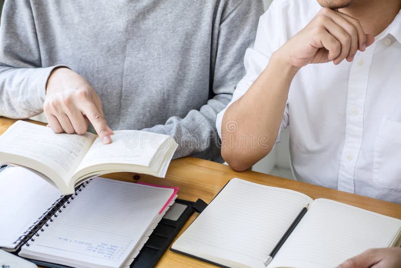 High School Tutor or College Student Group Sitting at Desk in Library ...
