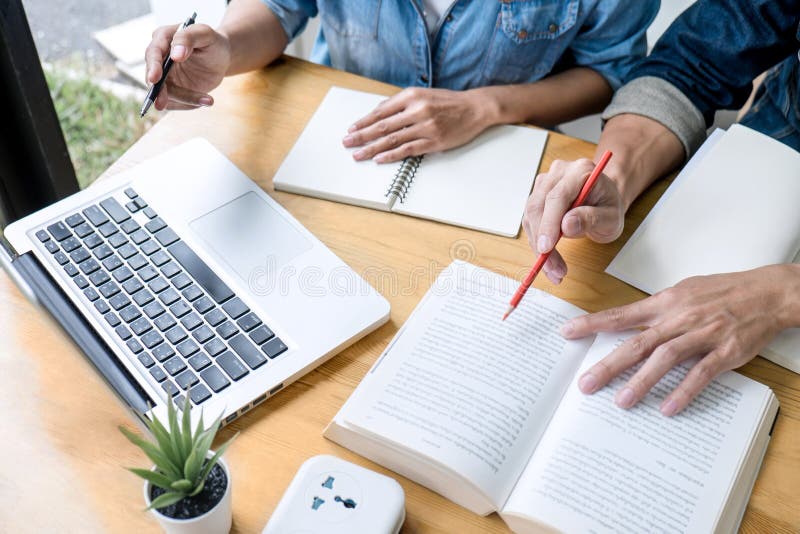High School Tutor or College Student Group Sitting at Desk in Library ...