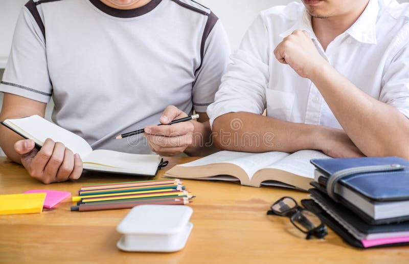 High School Tutor or College Student Group Sitting at Desk in Library ...