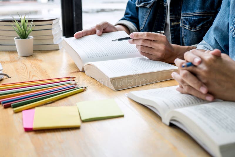 High School Tutor or College Student Group Sitting at Desk in Library ...