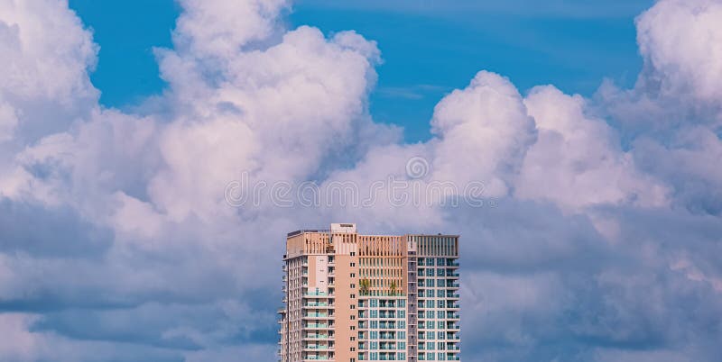 High Section of Modern Skyscraper Hotel Against Big Rain Clouds on Blue ...