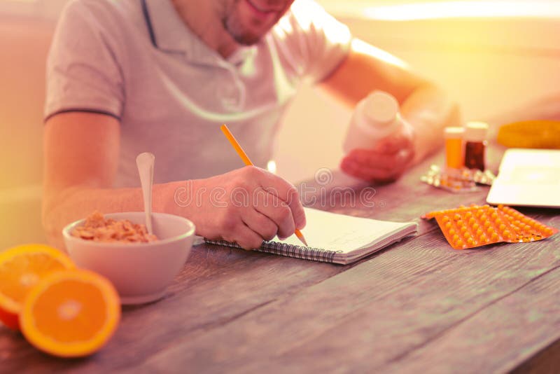 High-spirited Joyful Man Making Notes in His Notebook Stock Image ...