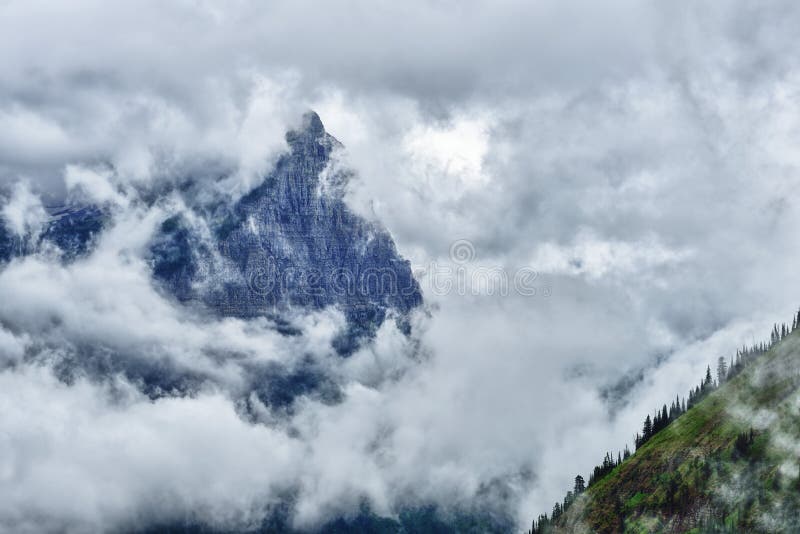 High and Steep Mountain Surrounded by Heavy Clouds Stock Image - Image ...