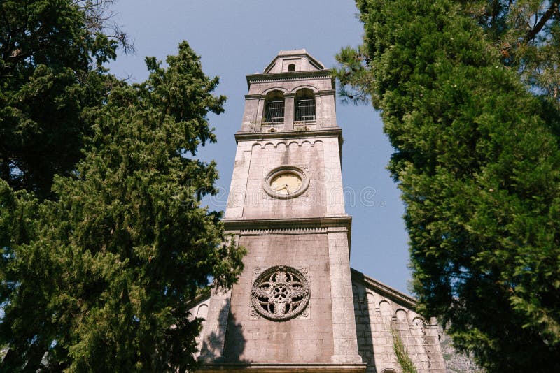High Stone Bell Tower with a Clock among the Trees Stock Image - Image ...