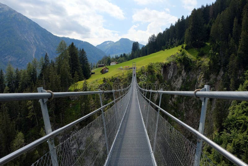 High Suspension Bridge between Mountains Trees and Rocks Stock Photo ...