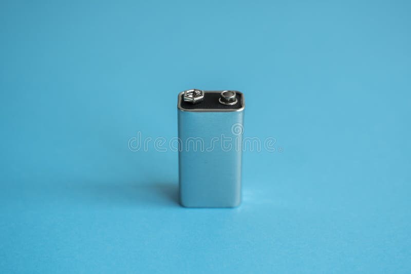 High Voltage Battery on a Blue Background. Silver Volt Battery. 9V ...