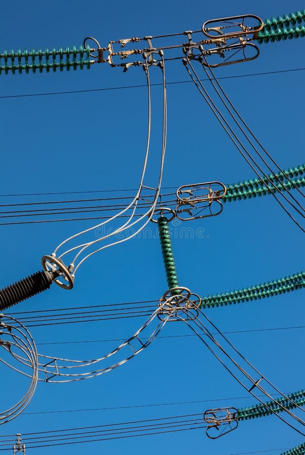High Voltage Electrical Power Lines and Isolators Against a Blue Stock ...