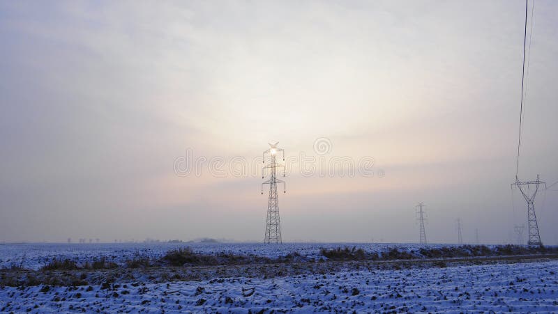 High Voltage Pole Illuminated by a Sun Hidden in the Mist Stock Image ...