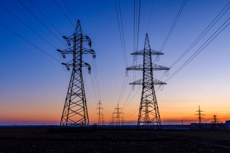 High Voltage Power Line in a Field at Sunset Stock Photo - Image of ...