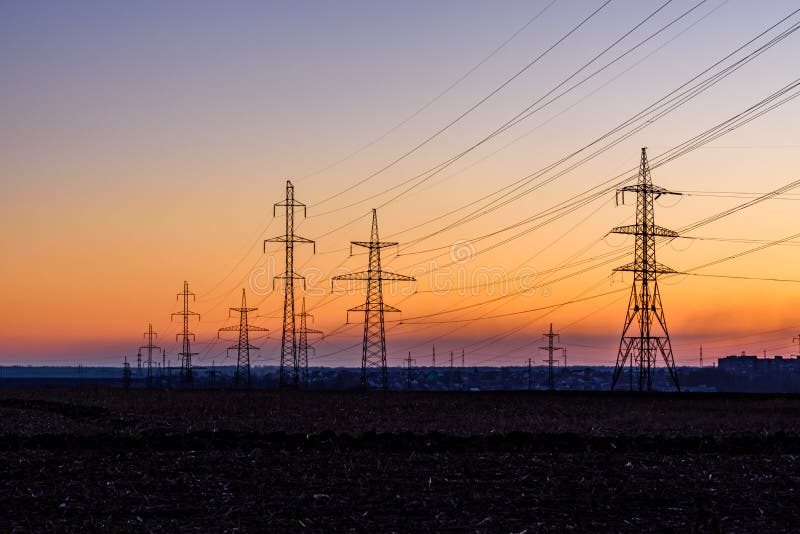 High Voltage Power Line in a Field at Sunset Stock Photo - Image of ...