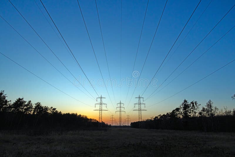 High Voltage Power Lines Over a Field at Sunset Stock Image - Image of ...