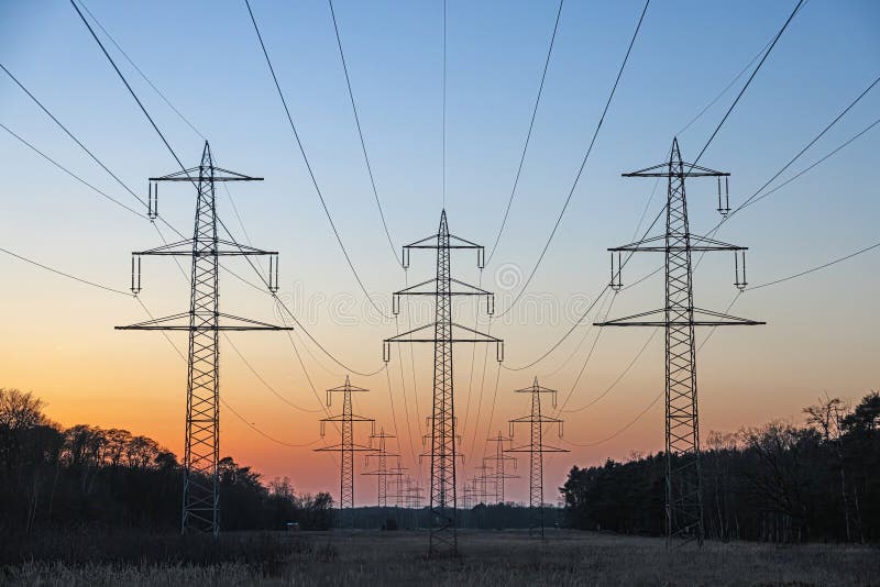 High Voltage Power Lines Over a Field at Sunset Stock Photo - Image of ...