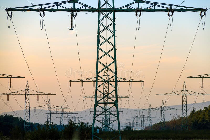 High Voltage Power Lines Over a Field at Sunset Stock Image - Image of ...