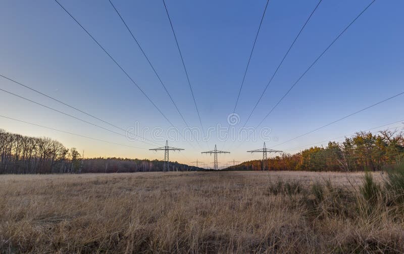 High Voltage Power Lines Over a Field at Sunset Stock Image - Image of ...