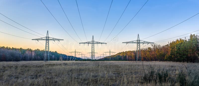 High Voltage Power Lines Over a Field at Sunset Stock Image - Image of ...