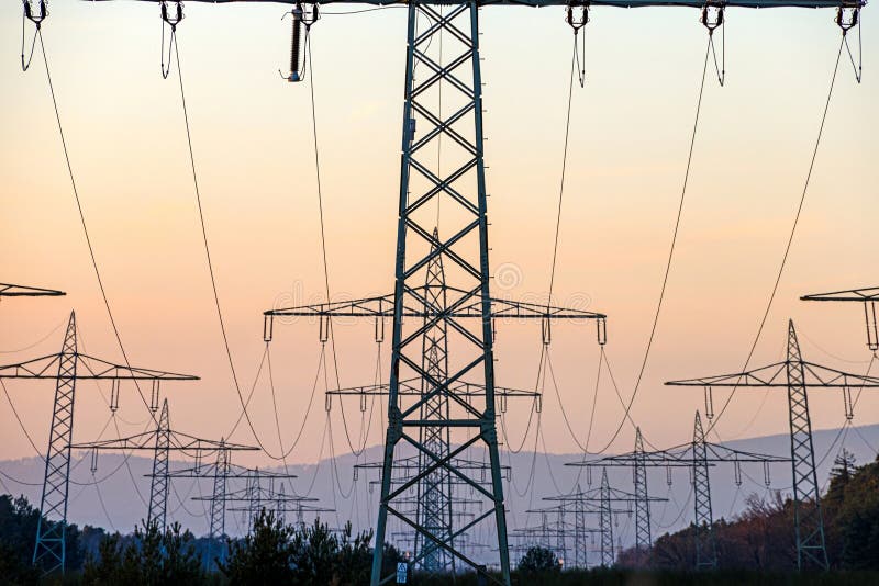 High Voltage Power Lines Over a Field at Sunset Stock Photo - Image of ...