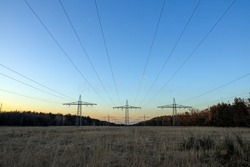 High Voltage Power Lines Over a Field at Sunset Stock Photo - Image of ...