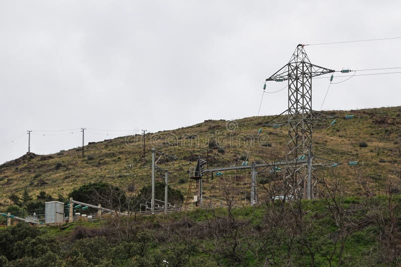 High-voltage Power Lines Stretch Across a Green Hillside. Stock Image ...