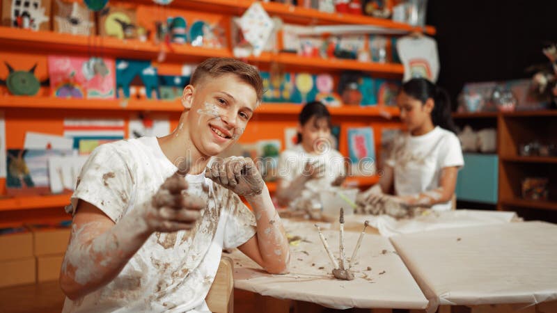 Highschool Boy Looking at Camera while Children Modeling Clay ...