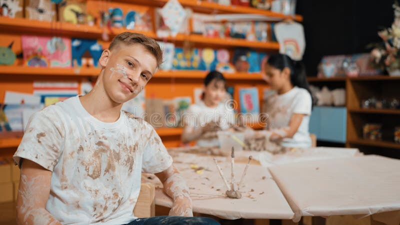 Highschool Boy Looking at Camera while Children Modeling Clay ...