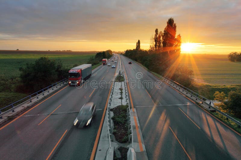 Highway with car at sunset stock image. Image of blurred - 44519329