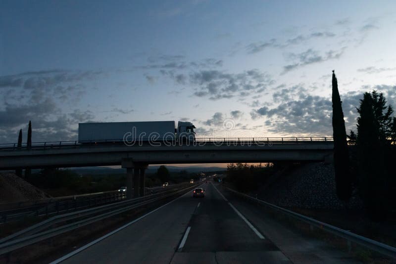 Highway at Dusk with Vehicles and a Bridge with a Truck Driving, Side ...