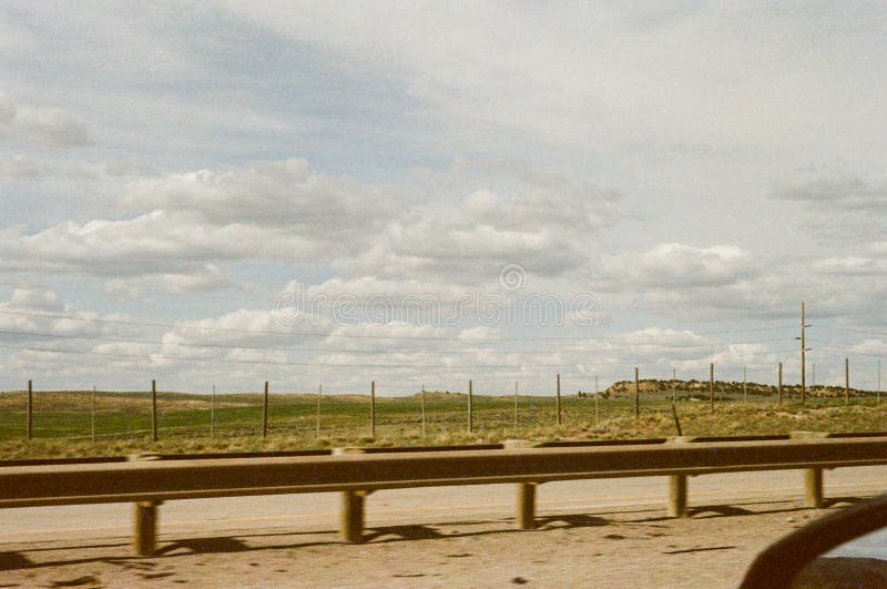 Highway Guardrail and Fence with Open Landscape and Cloudy Sky in ...