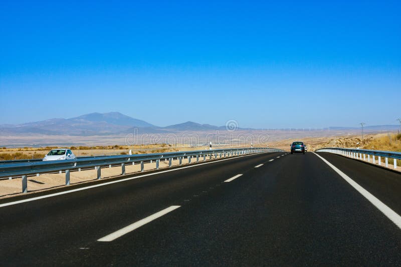 Highway in the Middle of the Dried Fields with Mountains in the ...