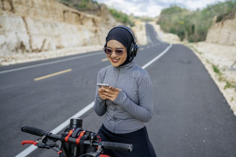 Hijab Biker Using Phone when Riding Bike Stock Image - Image of ...