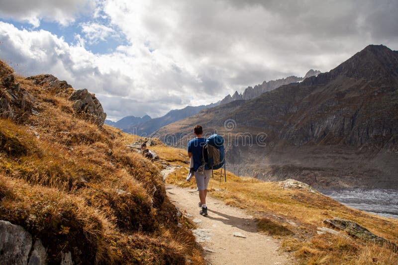 Hiker with a Backpack on a Mountain Route in the Swiss Alps Stock Photo ...