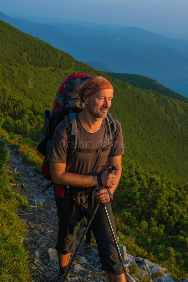 Hiker with Backpack is Resting and Looks at the Rising Sun in Mo Stock ...