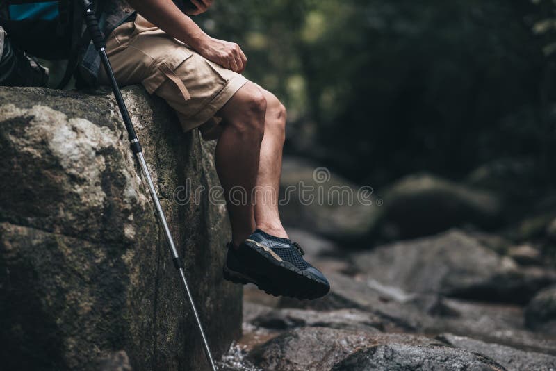 Hiker with Backpack Sitting on the Rock in Waterfall while a Rest ...