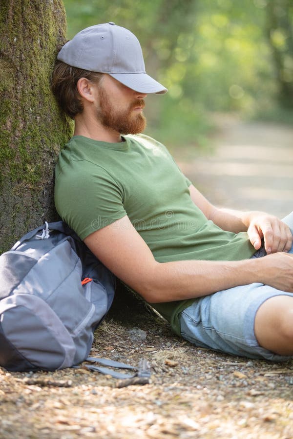 Hiker with Backpack Sleeping Against Tree in Forest Stock Photo - Image ...