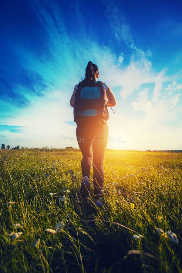 Hiker with Backpacks Walking through a Meadow Stock Photo - Image of ...